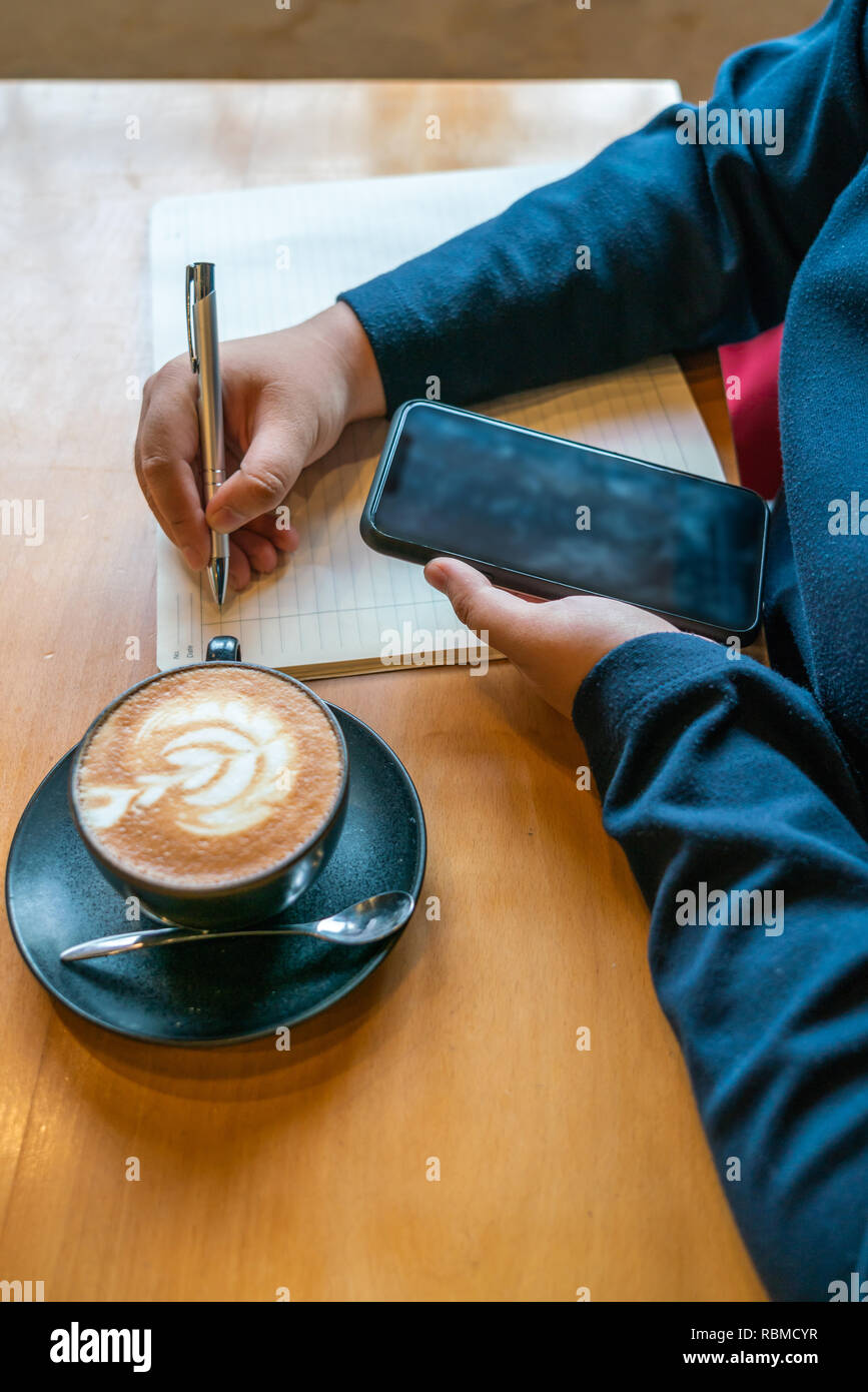 Vertical photo of young girl writing notes Stock Photo - Alamy