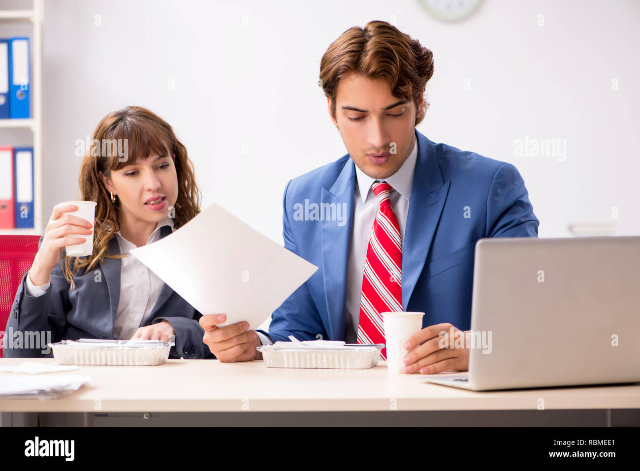 Two colleagues having lunch break at workplace Stock Photo - Alamy