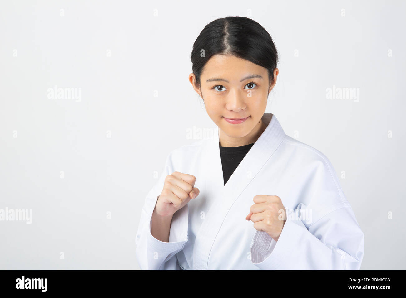 Young beautiful woman wearing karate suit performing karate on white ...