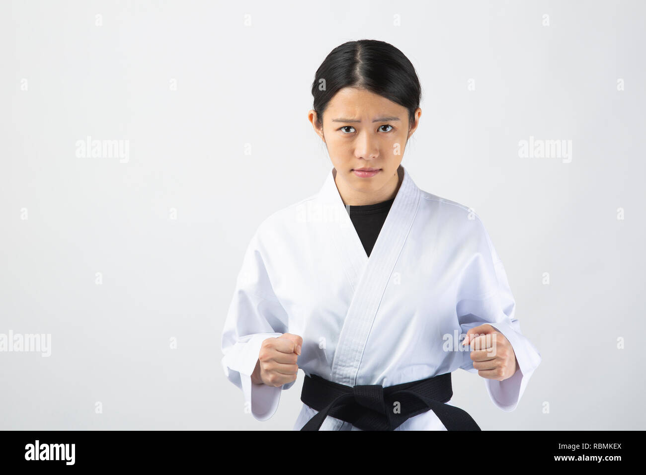 Young beautiful woman wearing karate suit performing karate on white ...