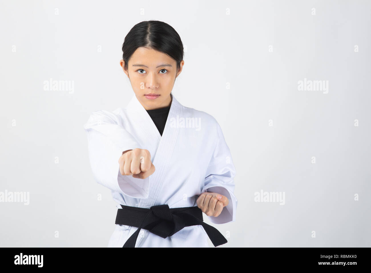 Young beautiful woman wearing karate suit performing karate on white ...