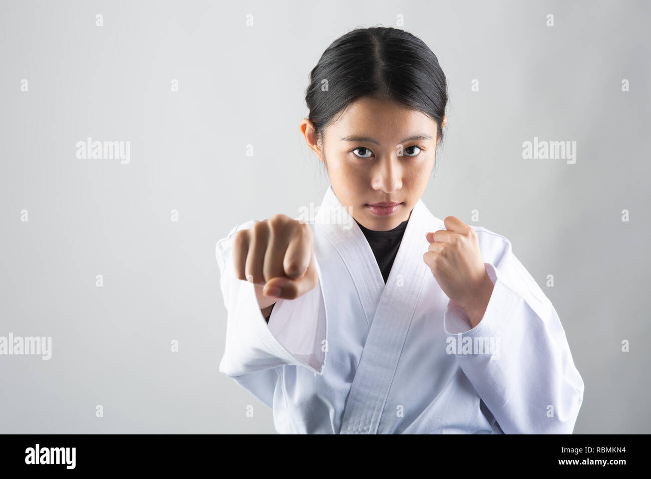Young beautiful woman wearing karate suit performing karate on white ...