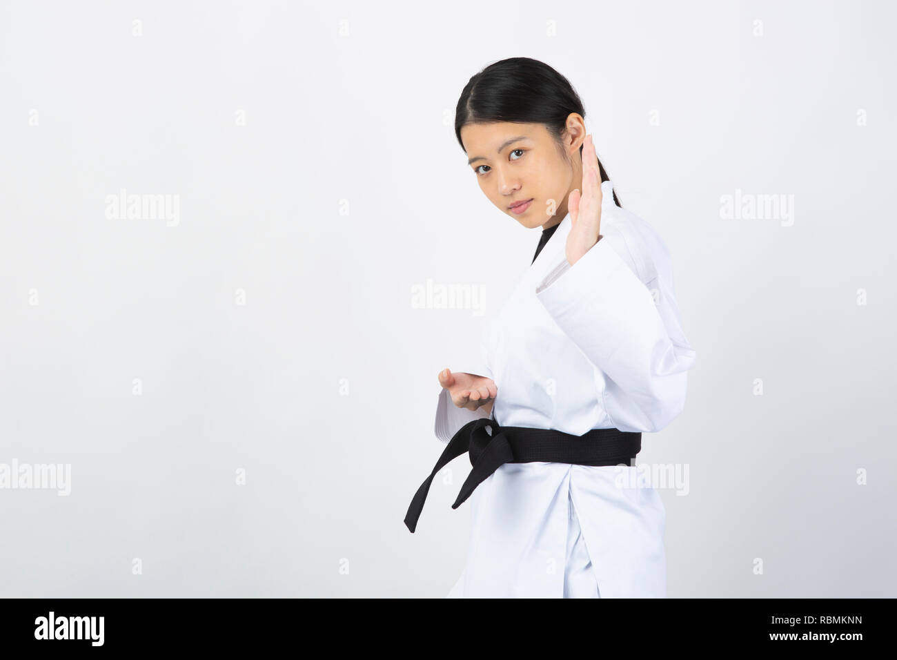Young beautiful woman wearing karate suit performing karate on white ...