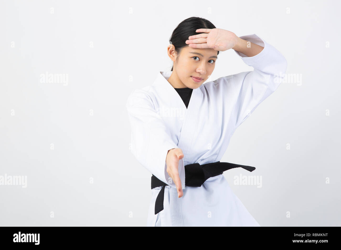 Young beautiful woman wearing karate suit performing karate on white ...