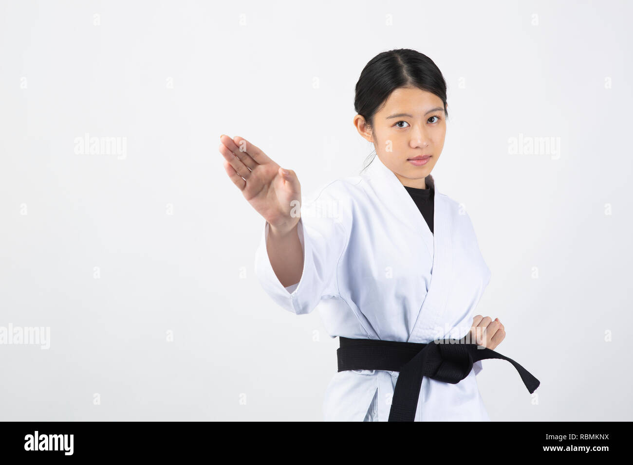 Young beautiful woman wearing karate suit performing karate on white ...