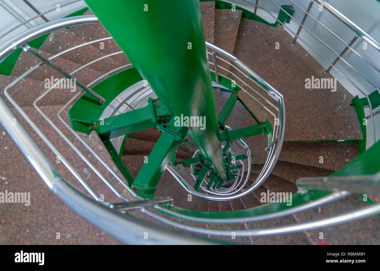 Spiral multi-flight stairway with metal handrails seen from the top of ...