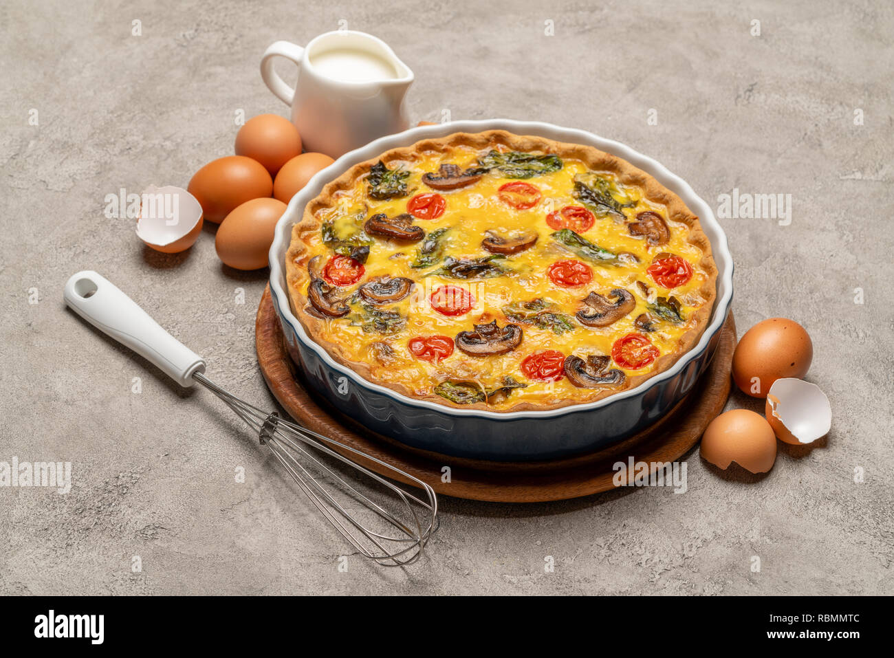 Baked homemade quiche pie in ceramic baking form, eggs and cream Stock ...