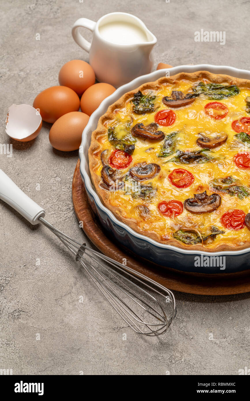 Baked homemade quiche pie in ceramic baking form, eggs and cream Stock ...
