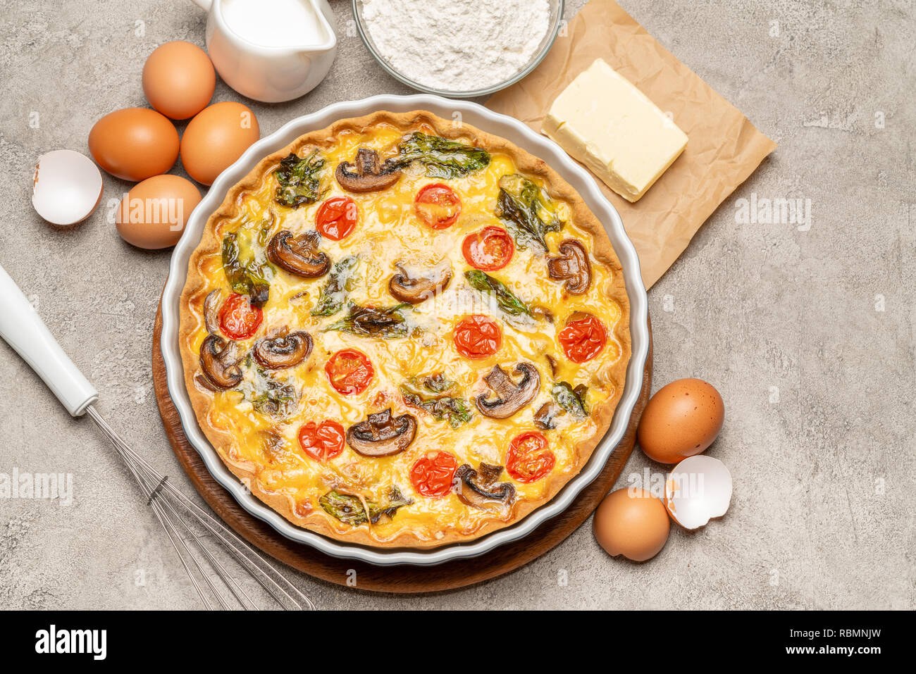 Baked homemade quiche pie in ceramic baking form, eggs and cream Stock ...