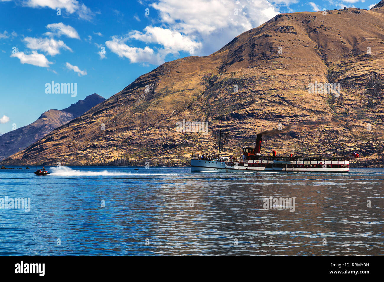 Steam-powered ship on lake Wakatipu surrounded by mountains in ...