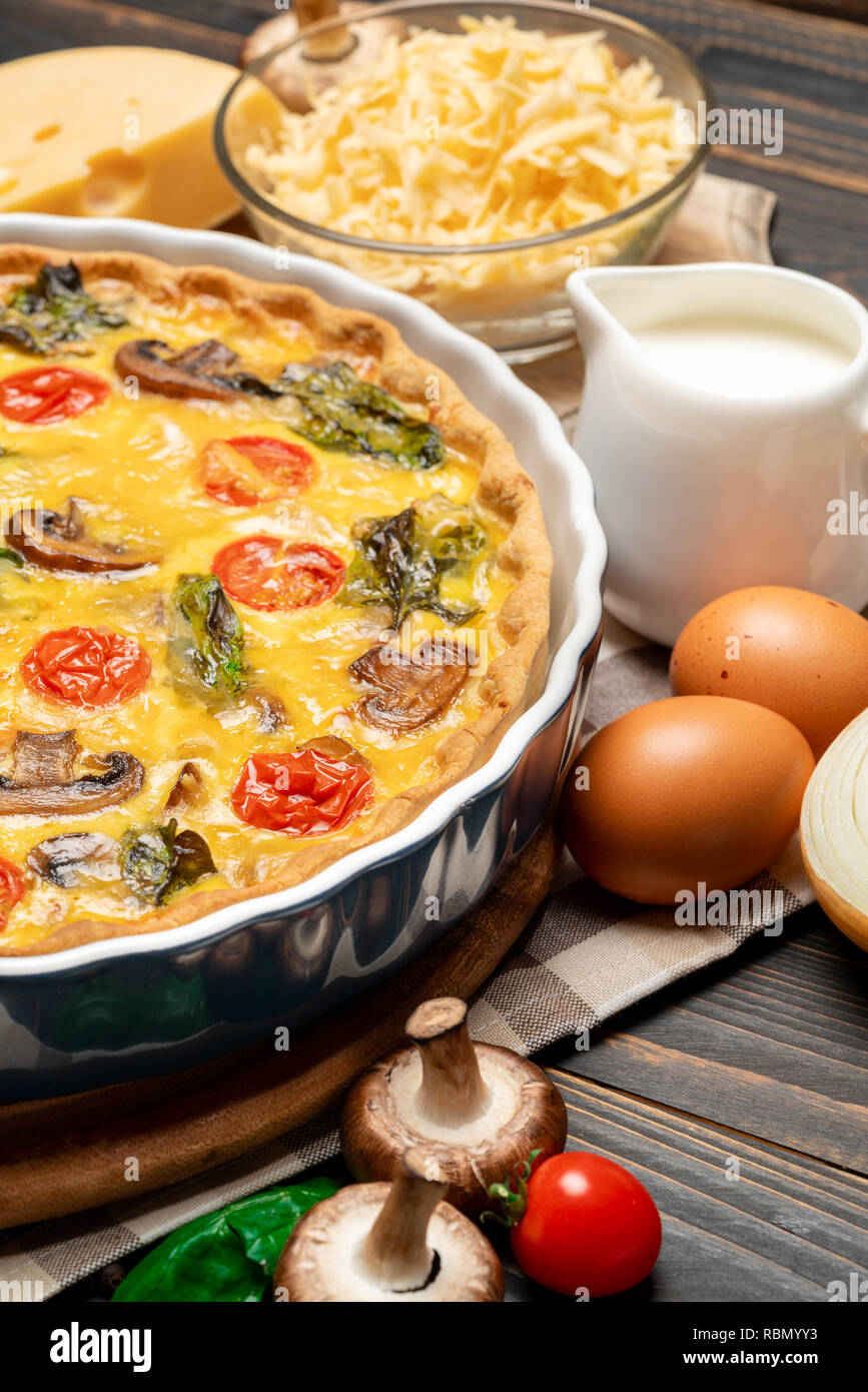 Baked homemade quiche pie in ceramic baking form, eggs and cream Stock ...