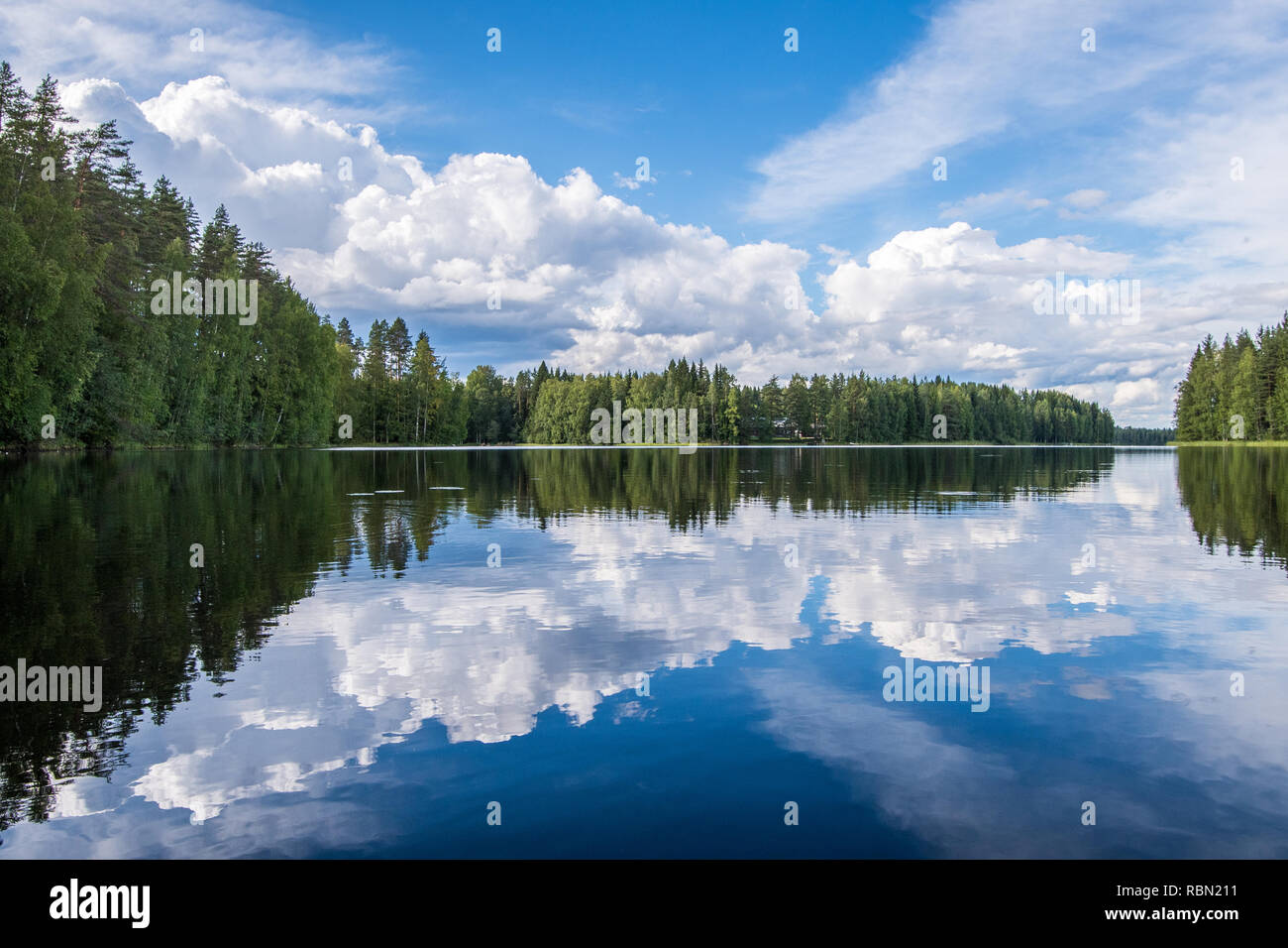 blue lake and sky with trees in reflection Stock Photo - Alamy