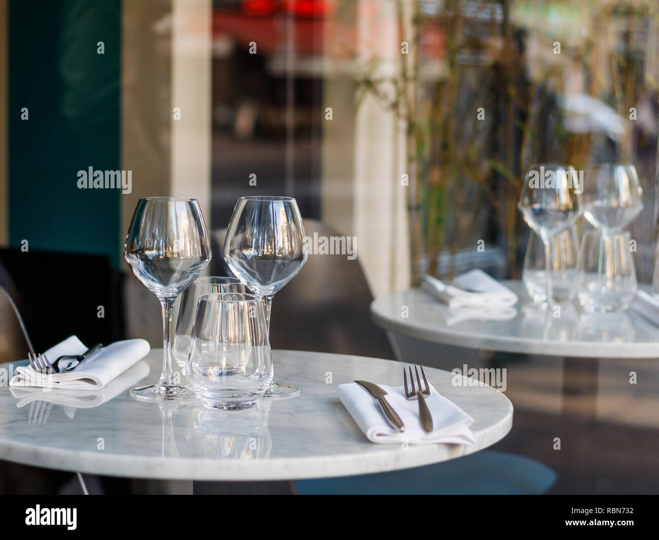 Table setting in a French restaurant for two. View through a window ...