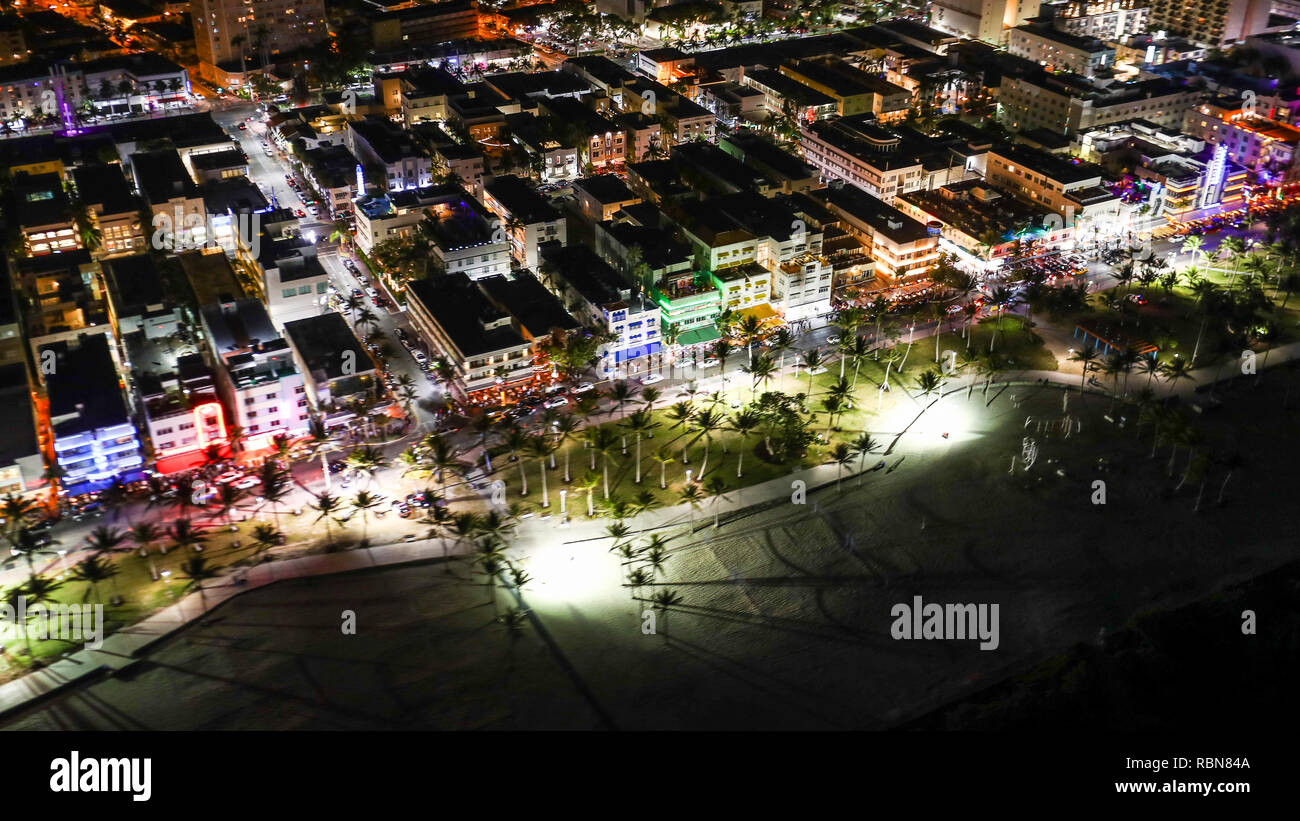helicopter view over ocean drive, miami, on a busy night with colorful ...