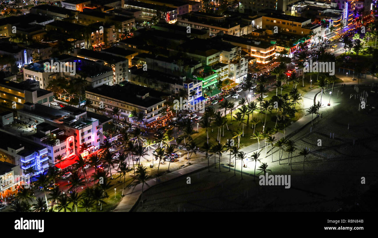 helicopter view over ocean drive, miami, on a busy night with colorful ...