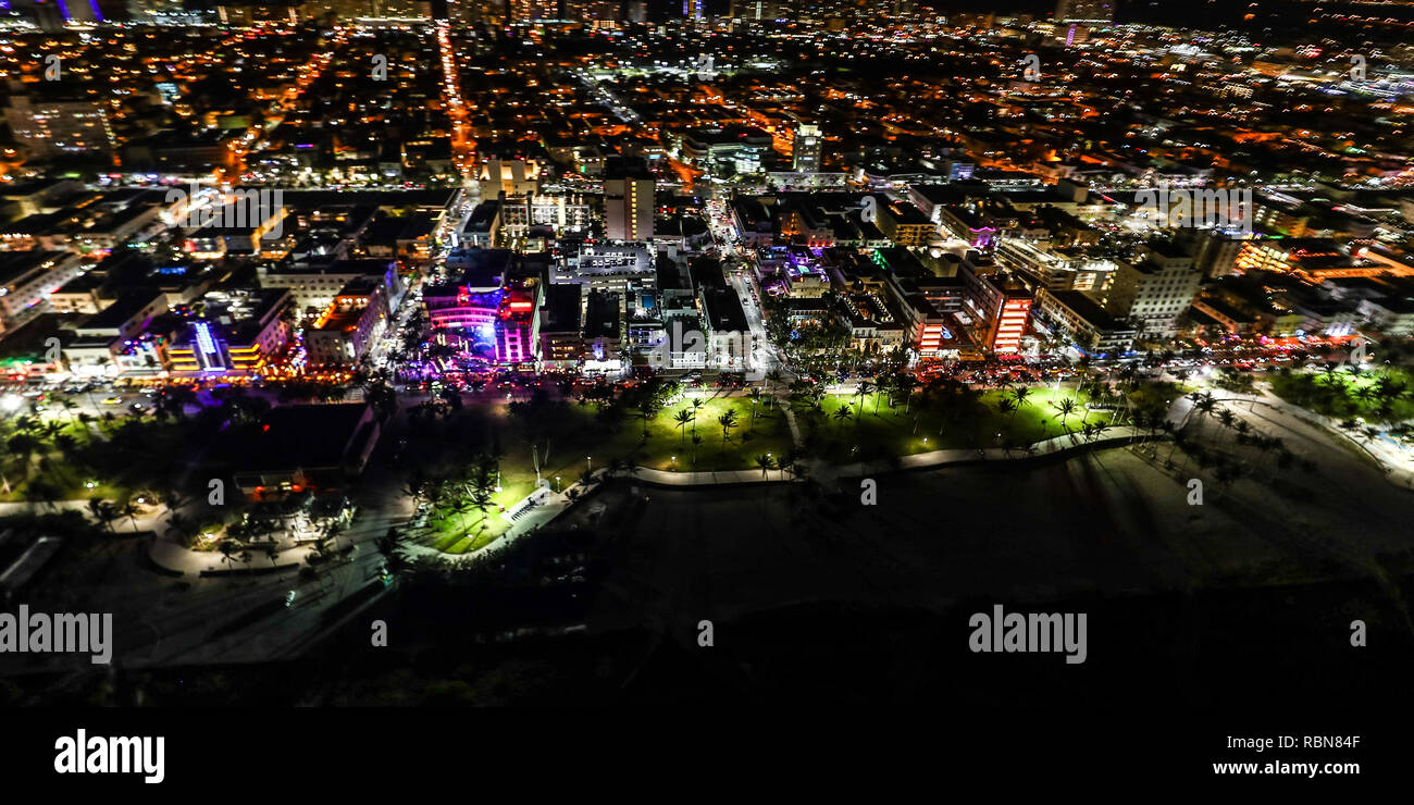 helicopter view over ocean drive, miami, on a busy night with colorful ...