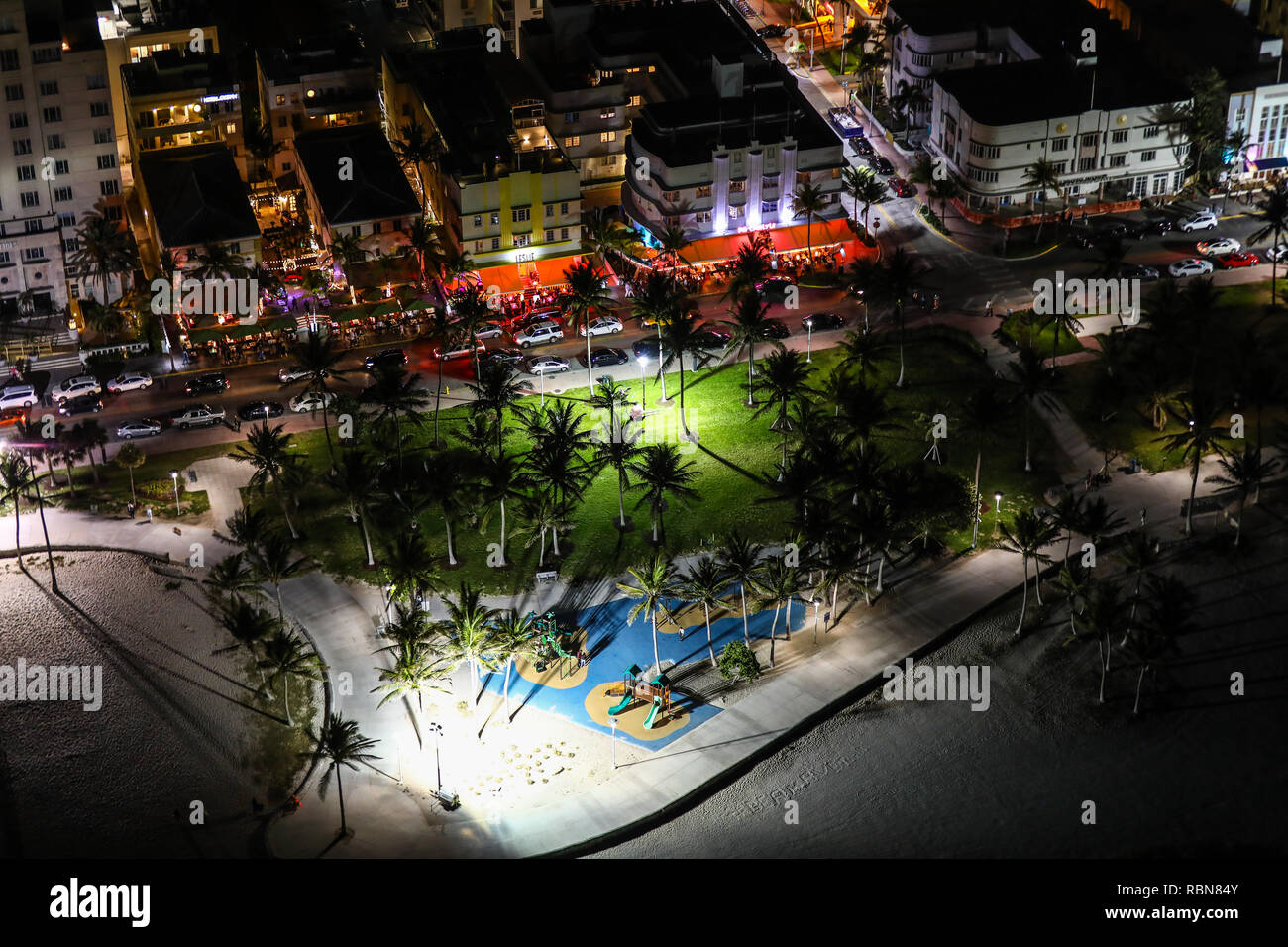 helicopter view over ocean drive, miami, on a busy night with colorful ...