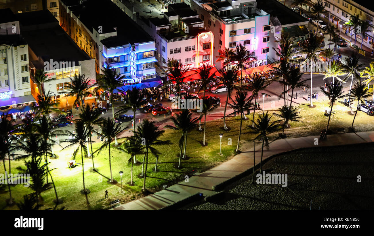 helicopter view over ocean drive, miami, on a busy night with colorful ...