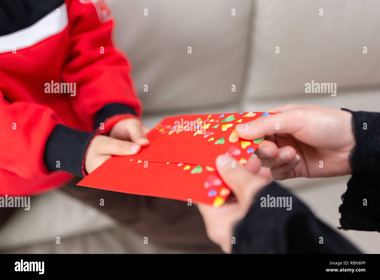 mum giving a red pocket to her son Stock Photo - Alamy