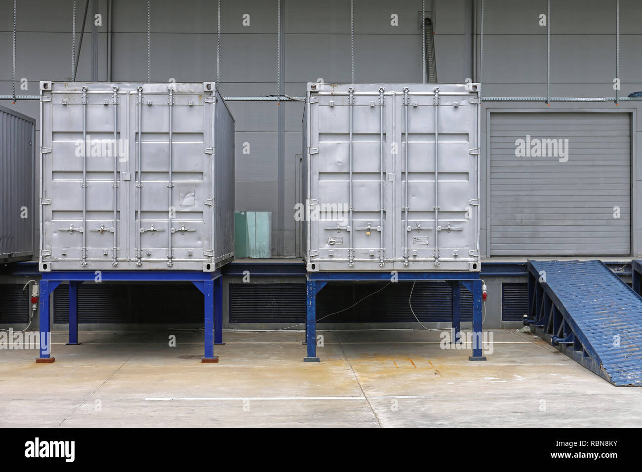 Two Shipping Containers With Leg Support in Front of Warehouse Stock ...