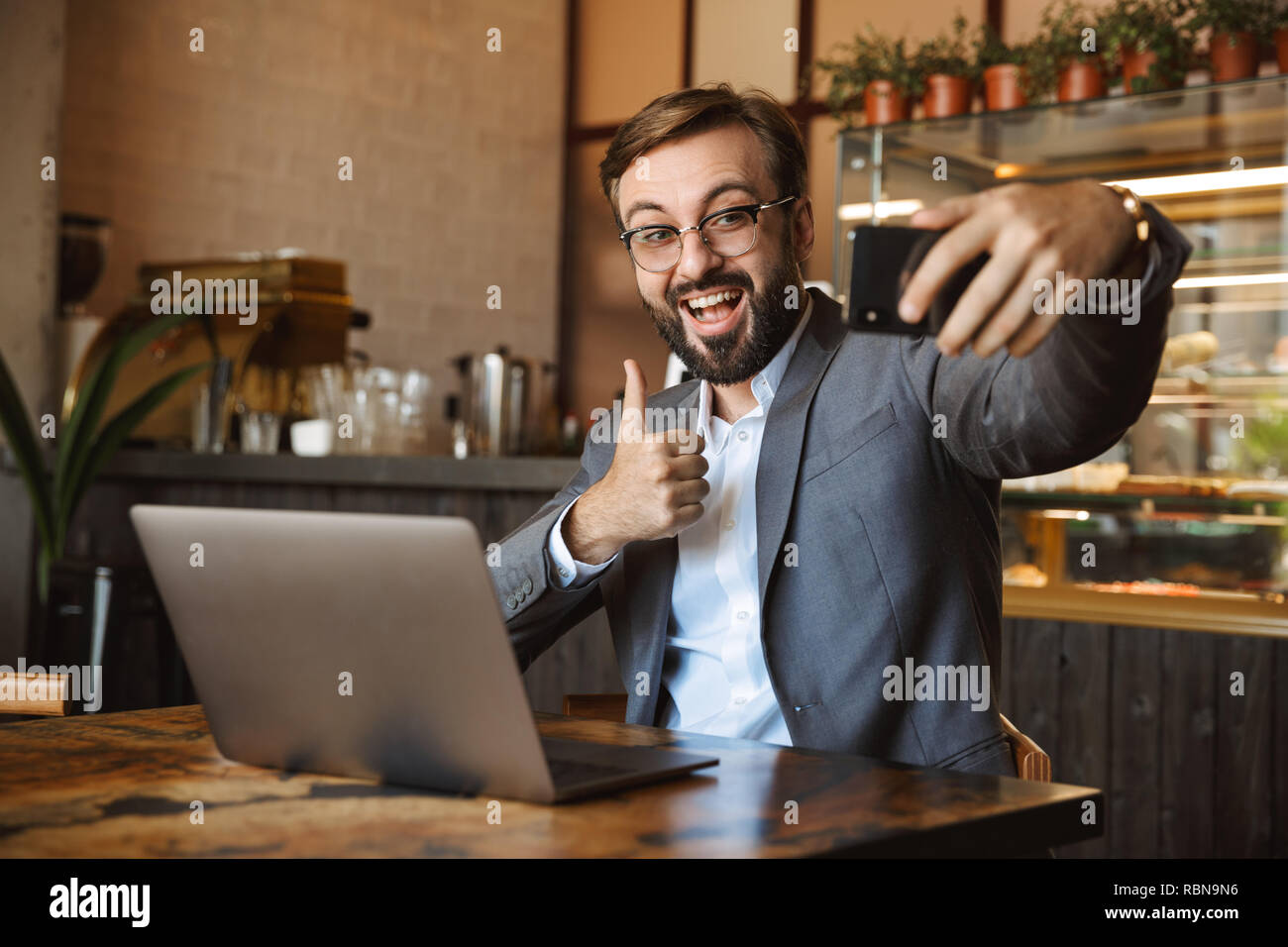 Handsome young businessman dressed in suit working on a laptop computer ...