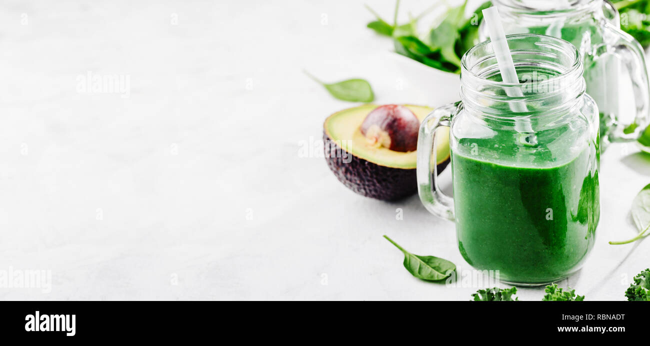 Fresh made healthy green smoothie served in jars on bright table ...