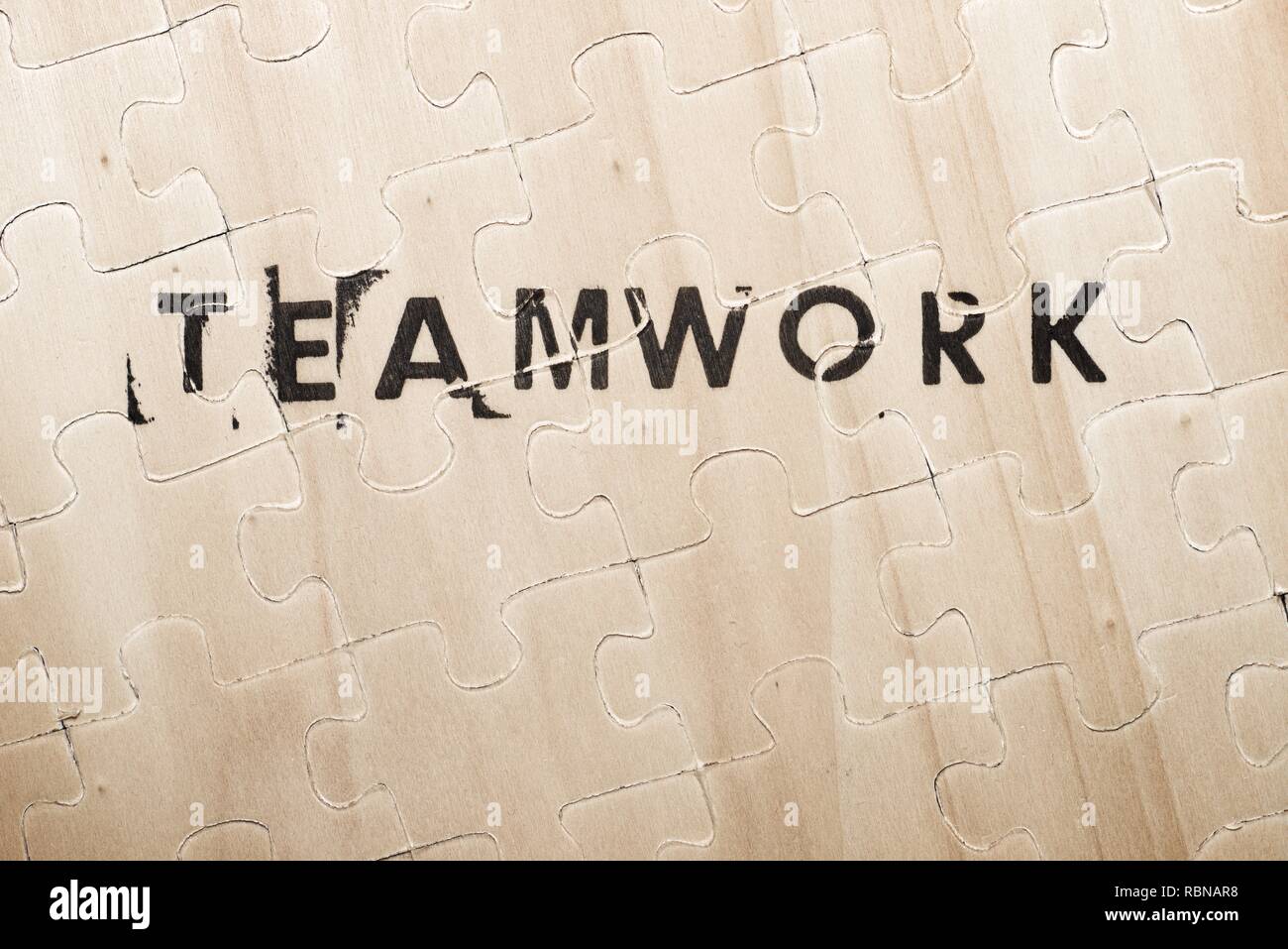Teamwork word stamped on a wooden puzzle Stock Photo - Alamy