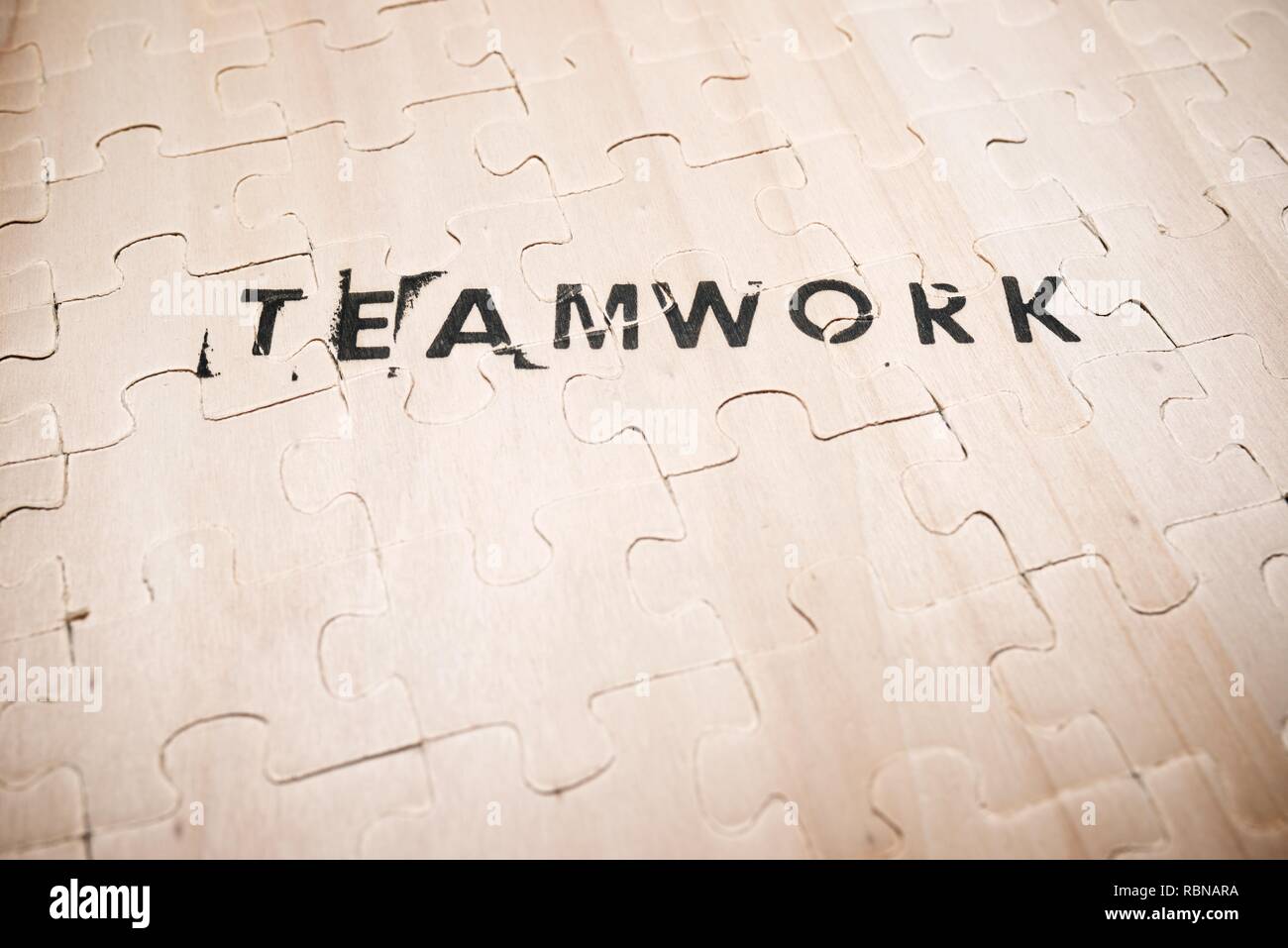 Teamwork word stamped on a wooden puzzle Stock Photo - Alamy
