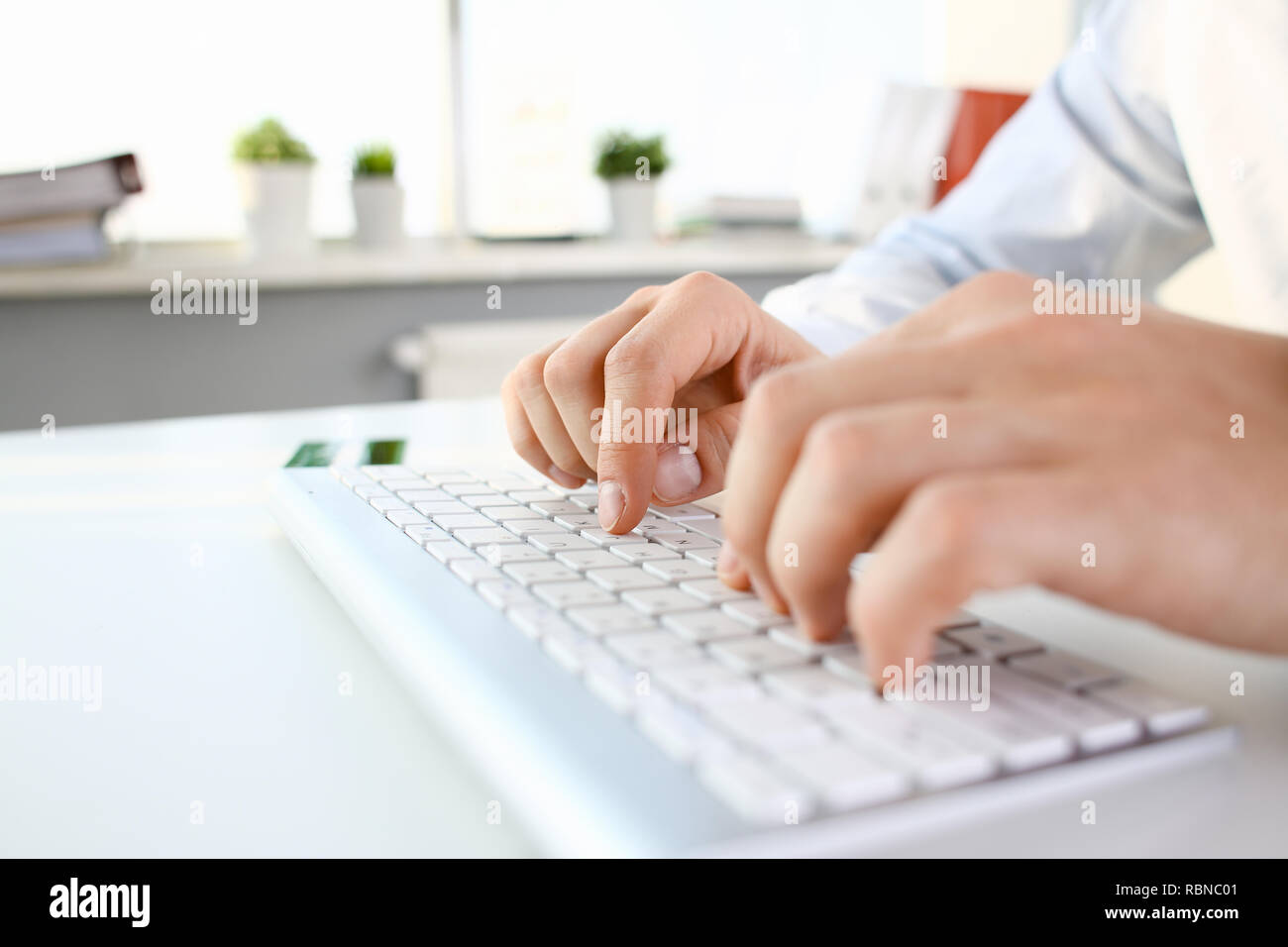 Male arms in suit typing on silver keyboard Stock Photo - Alamy