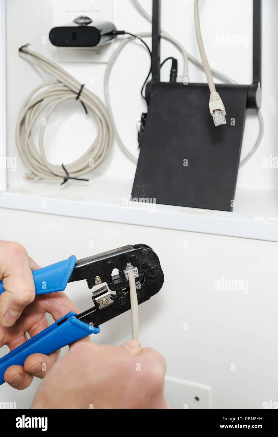 Connecting wi-fi router to the Internet. Hands man fixing cable ...