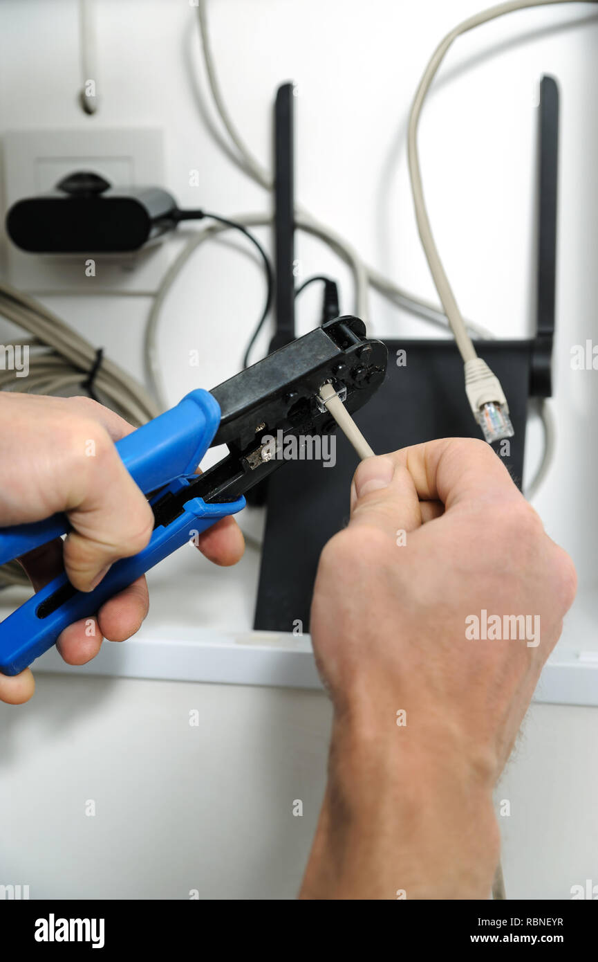 Connecting wi-fi router to the Internet. Hands man fixing cable ...