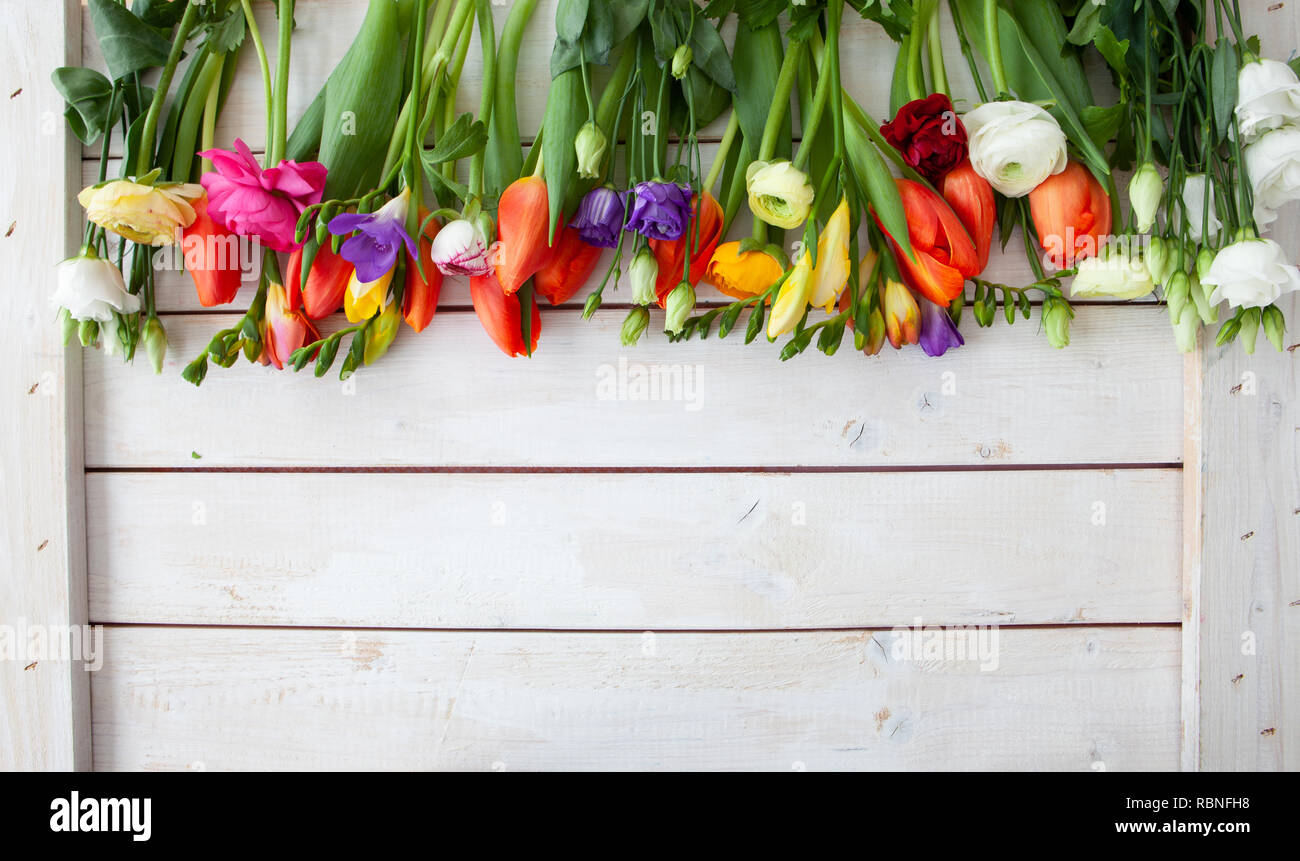 Colorful spring flowers on a rustic wooden background Stock Photo - Alamy