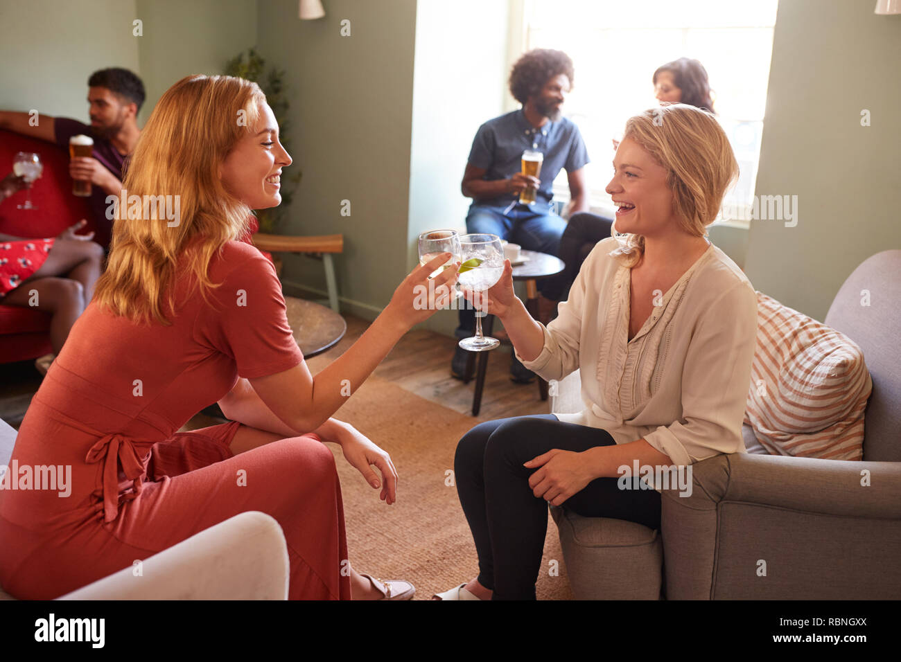 Two women laughing in sofa hi-res stock photography and images - Alamy