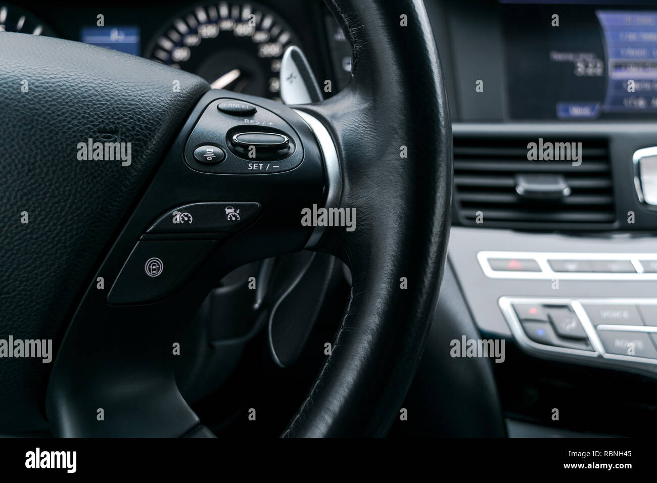 Cruise control buttons on the steering wheel of a modern car with black ...