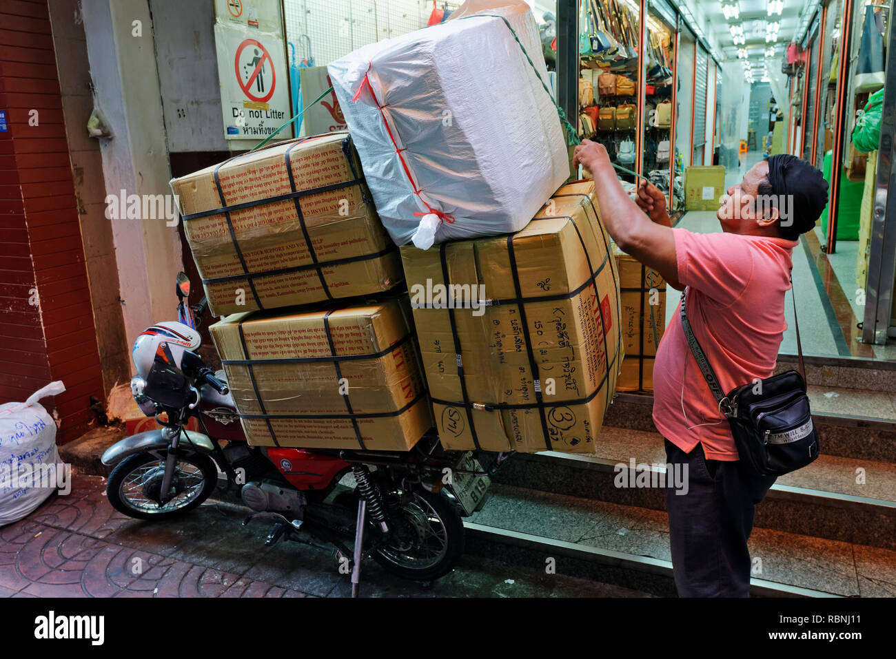 delivery boy on motorcycle in the narrow street Soi Wanit 1, Chinatown ...