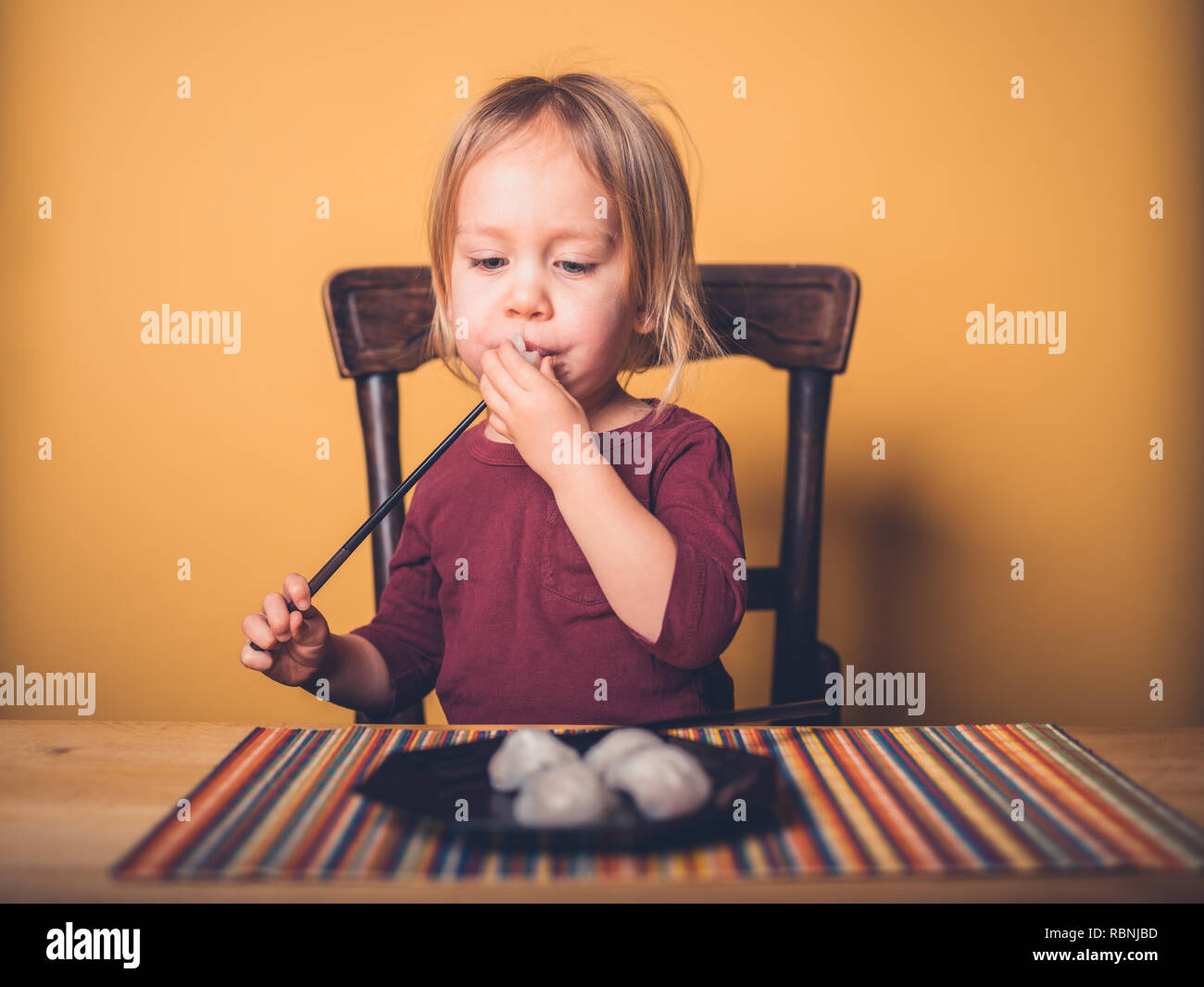 A little toddler is eating Dim sum with chop sticks Stock Photo - Alamy