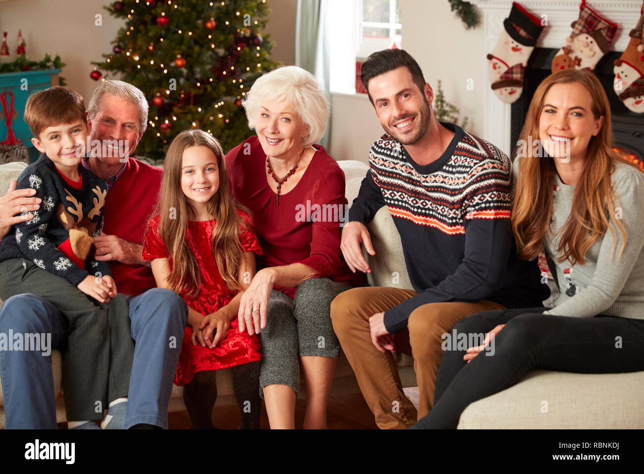 Portrait Of Multi Generation Family Sitting On Sofa In Lounge At Home ...