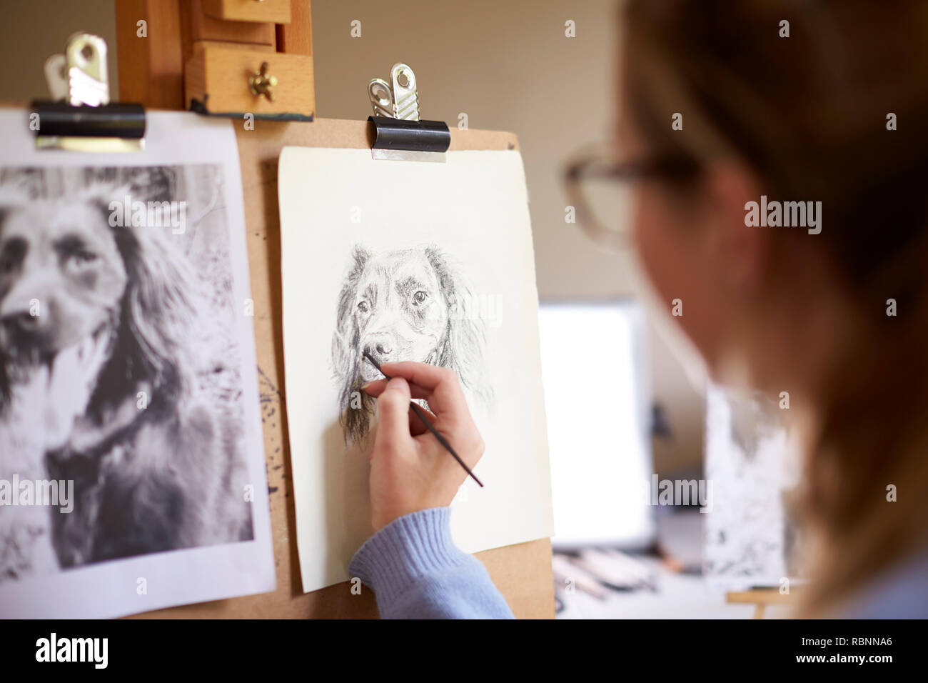 Rear View Of Female Teenage Artist Sitting At Easel Drawing Picture Of ...