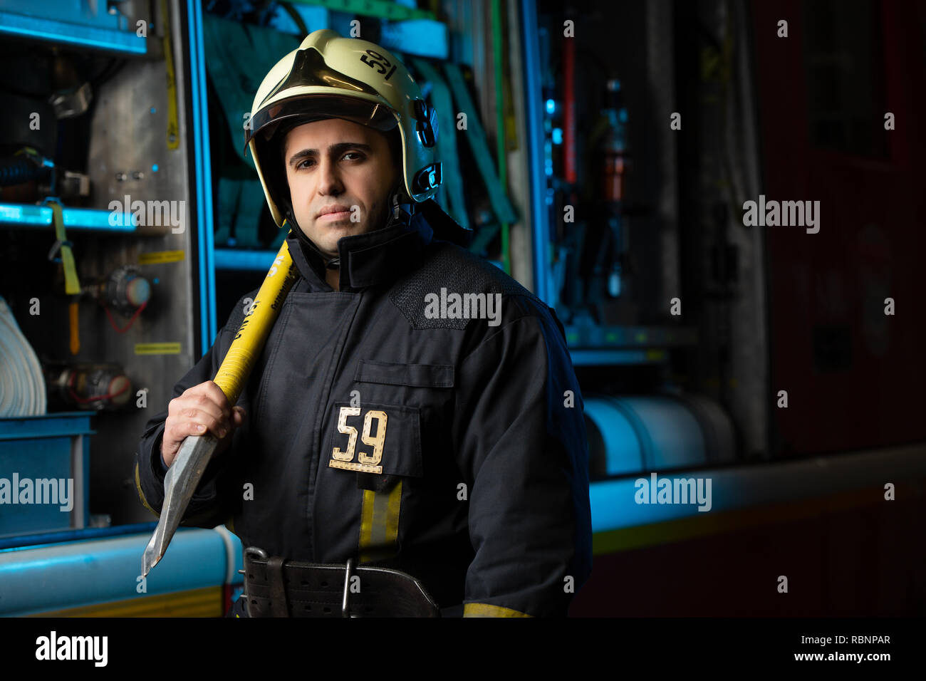 Picture of man firefighter with pick near fire truck at station Stock ...