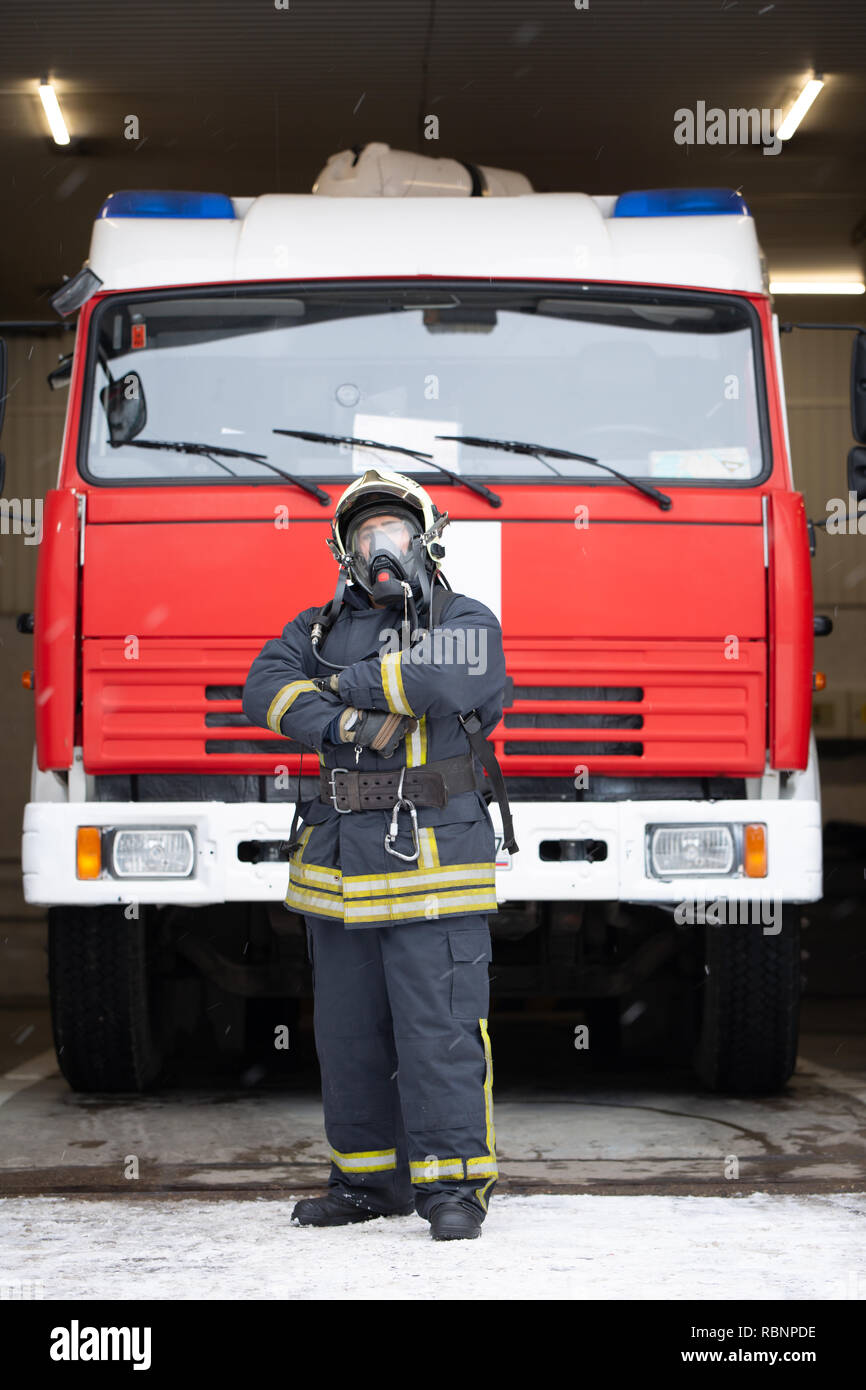 Full-length photo of man fireman in gas mask near fire truck Stock ...