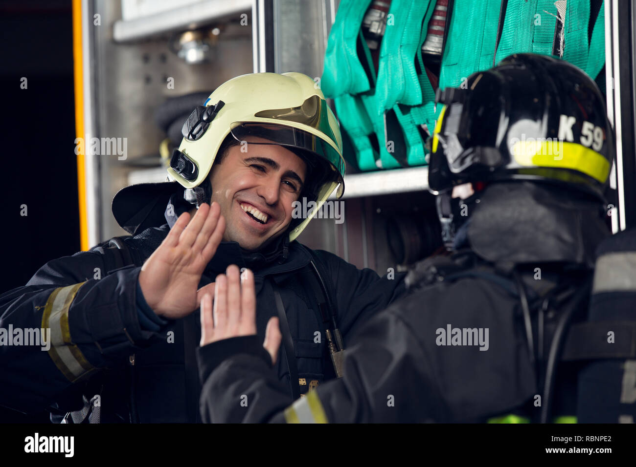 Picture of two firemen men making handshake near fire truck Stock Photo ...