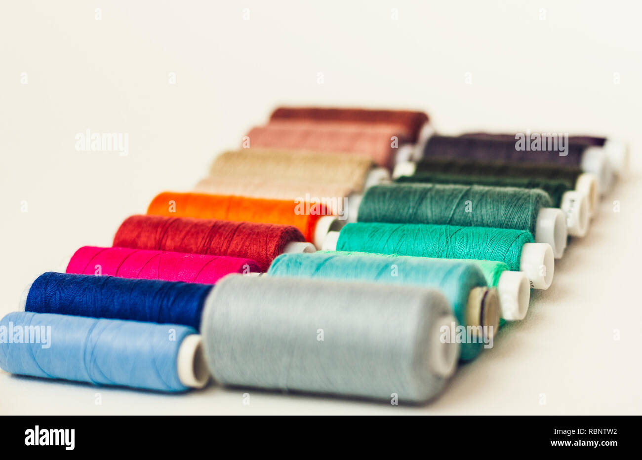 Colored sewing thread coils on white background with copy space for ...