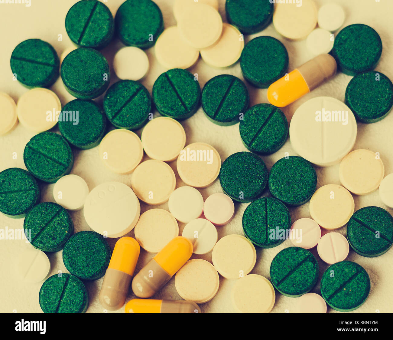 Medicine green, pink and yellow pills or capsules on white background ...