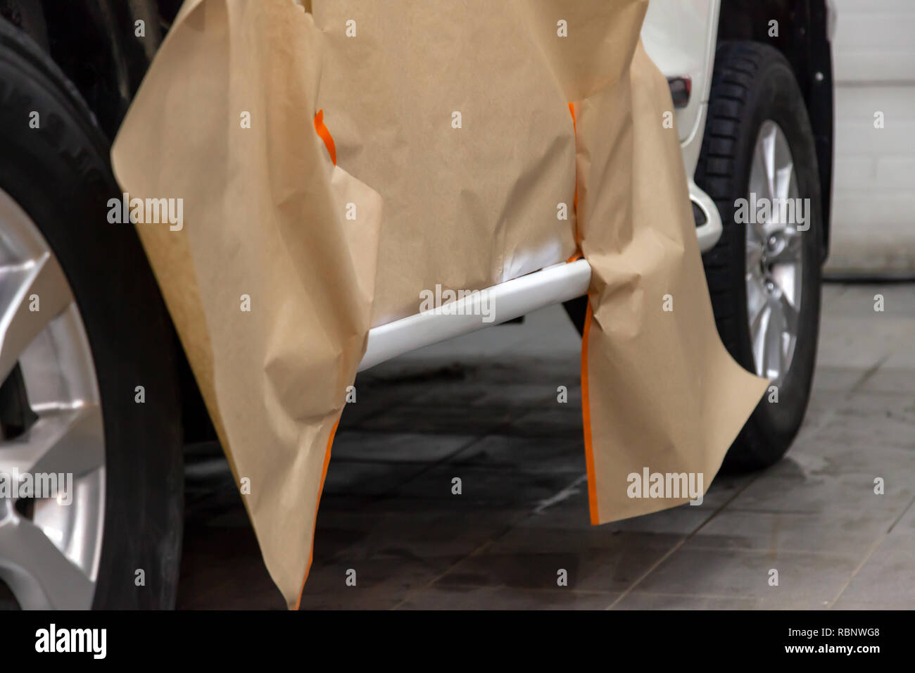 Partial painting of the lower elements of the body of a white SUV car ...