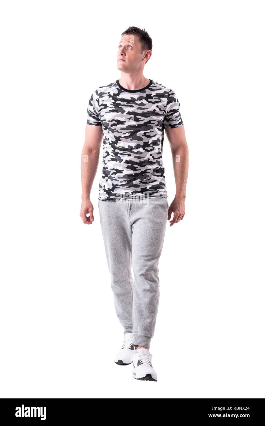 Confused young fit man in sporty clothes walking and looking up. Full ...