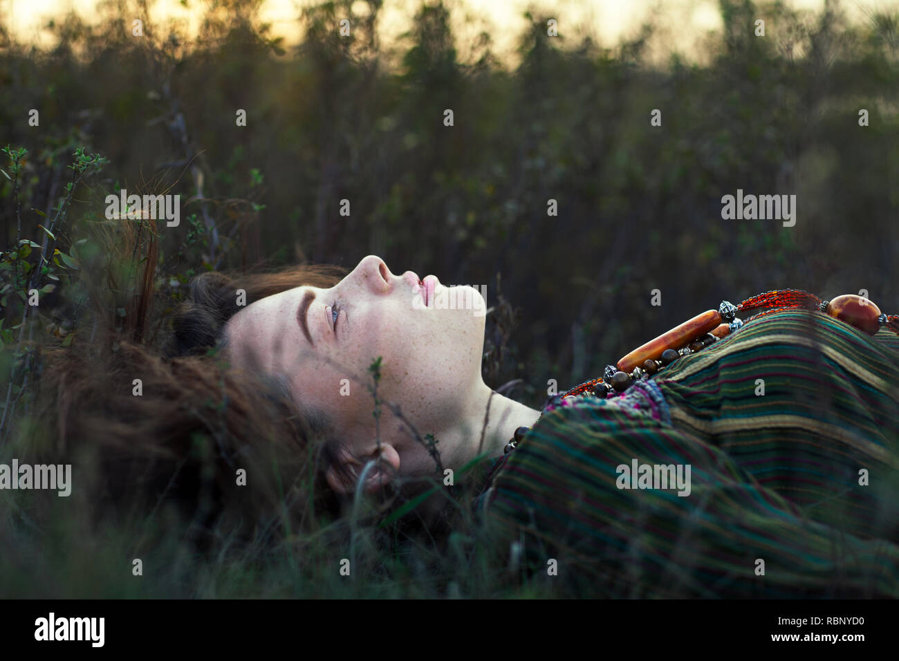 Portrait of beautiful hippie girl lying on the grass. Relax and beauty ...