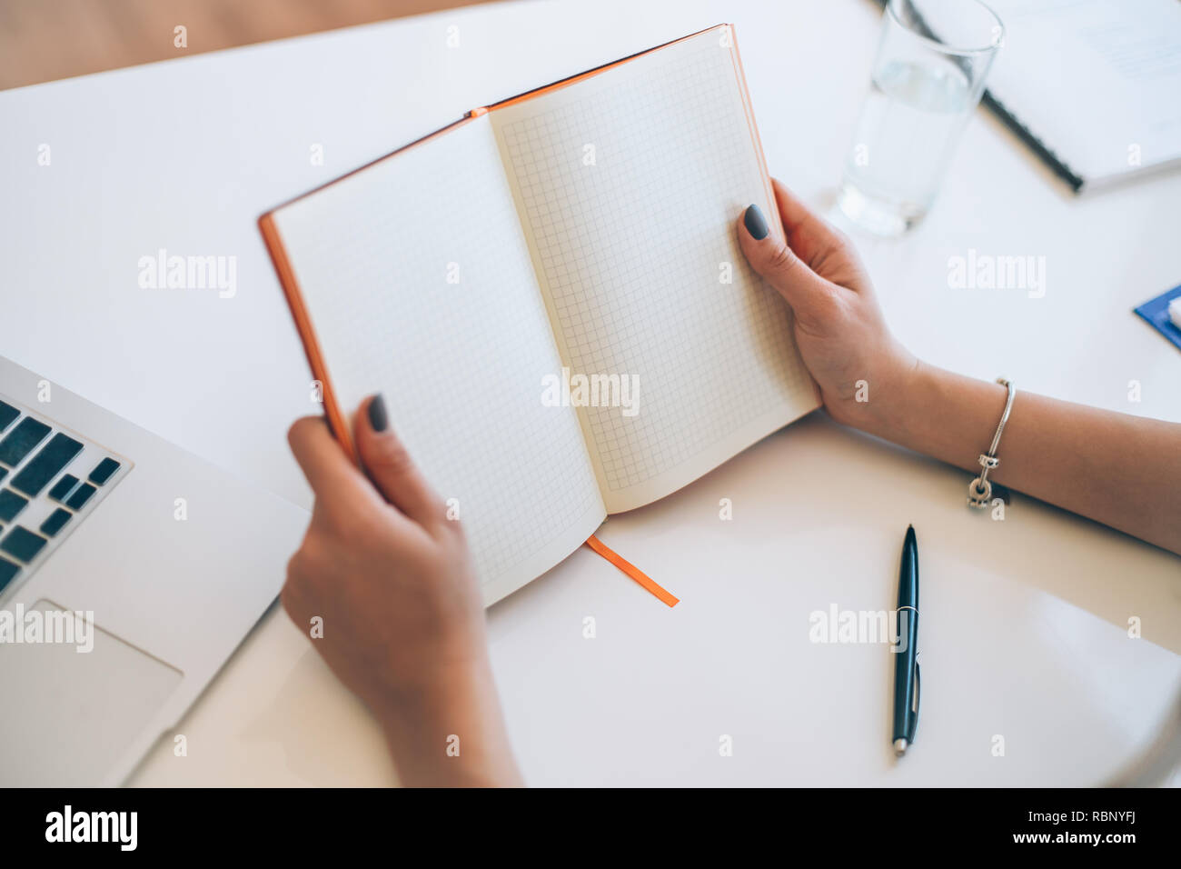 Young woman hands hold opens blank notebook in office supplies ...