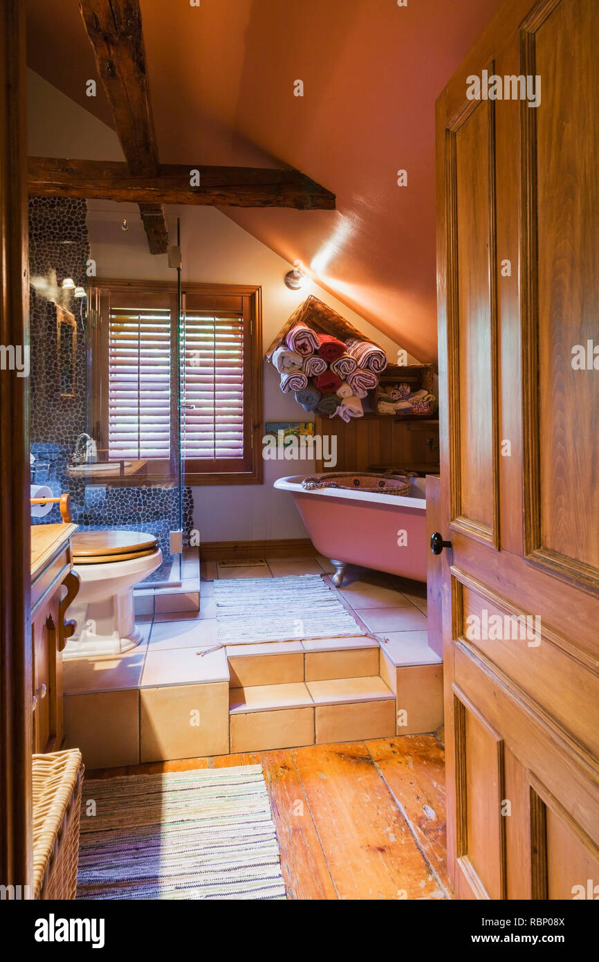 Main bathroom with toilet and clawfoot bathtub on raised ceramic tile ...