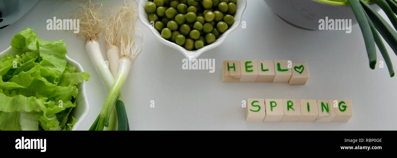 Fresh raw spring vegetables on white background, text " Hello spring ...