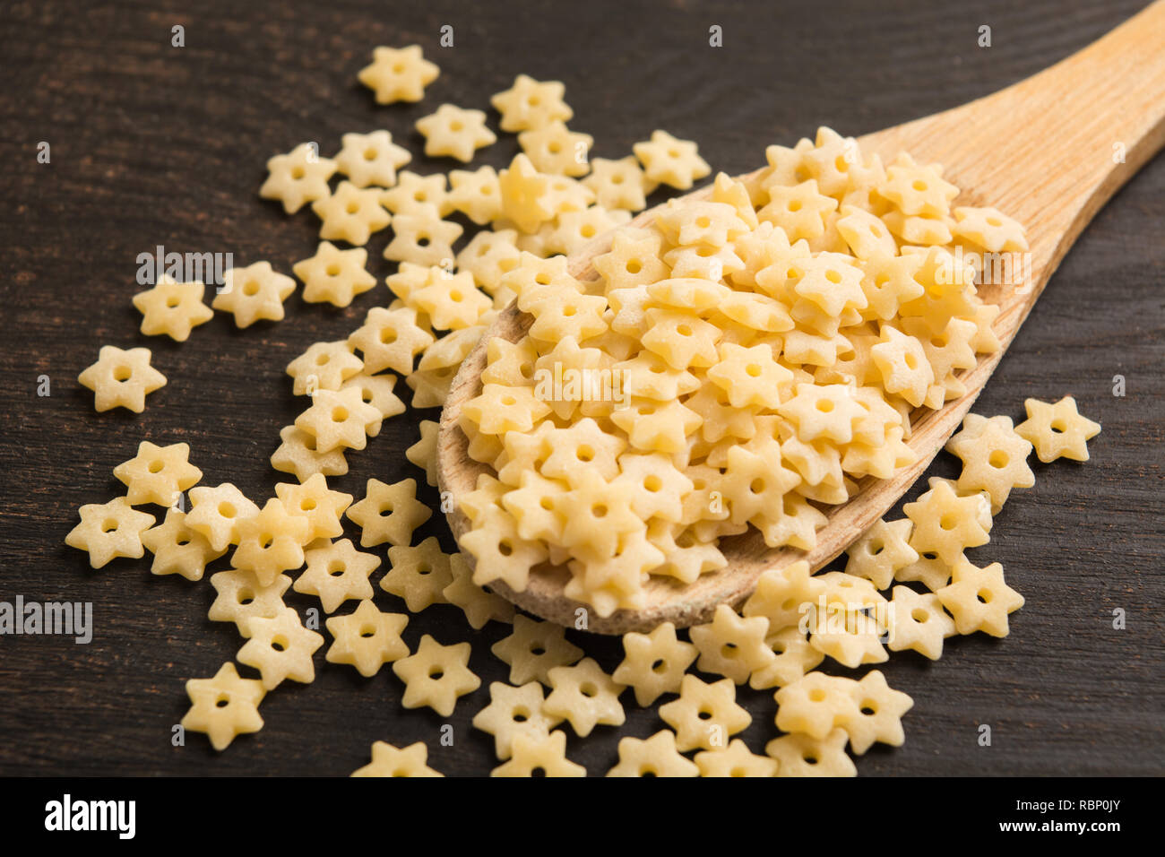 Dry raw star pasta with spoon on wooden table, closeup view Stock Photo ...